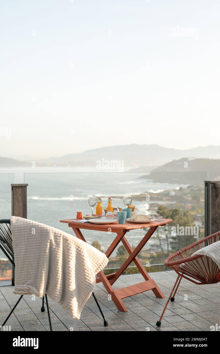 Outdoor breakfast table with sea view during sunrise. Warm morning ...