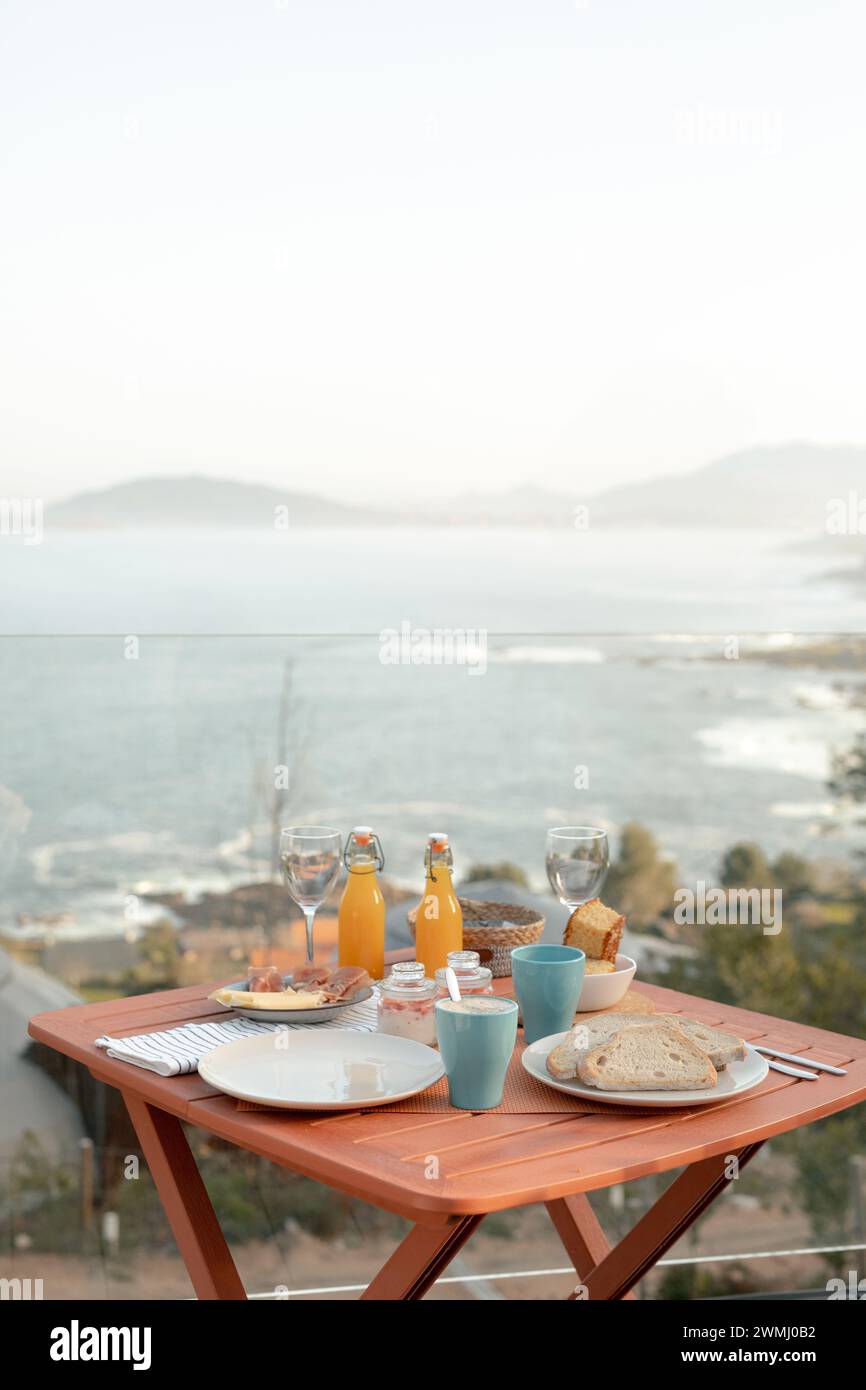 Breakfast table setup with sea view. Outdoor dining photography with ...