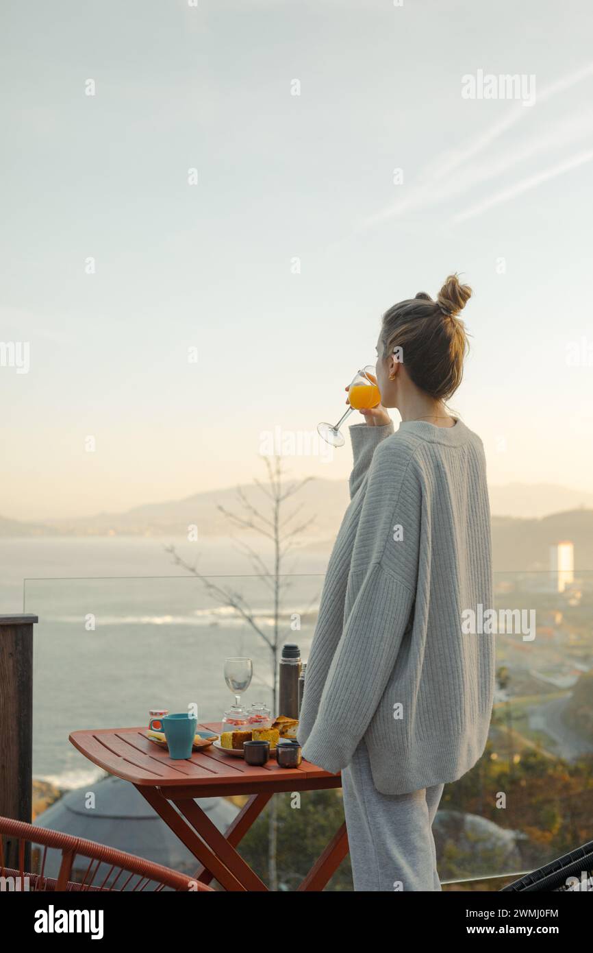 Seaside Morning Bliss: Woman Sipping Orange Juice Enjoying the Sunrise ...