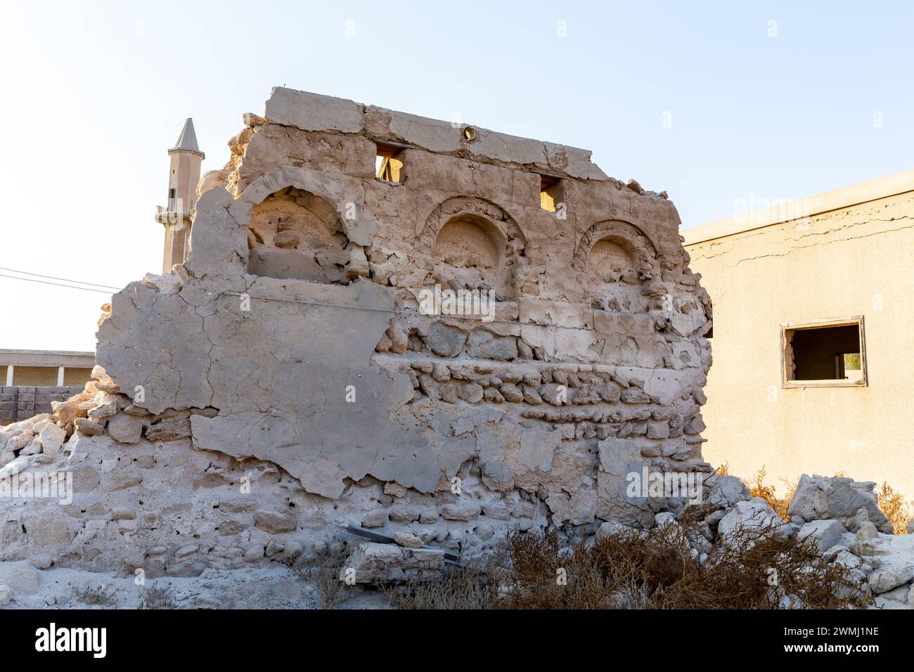 Ruined residential building wall with arabic style arch windows in Al Jazirah Al Hamra haunted ...