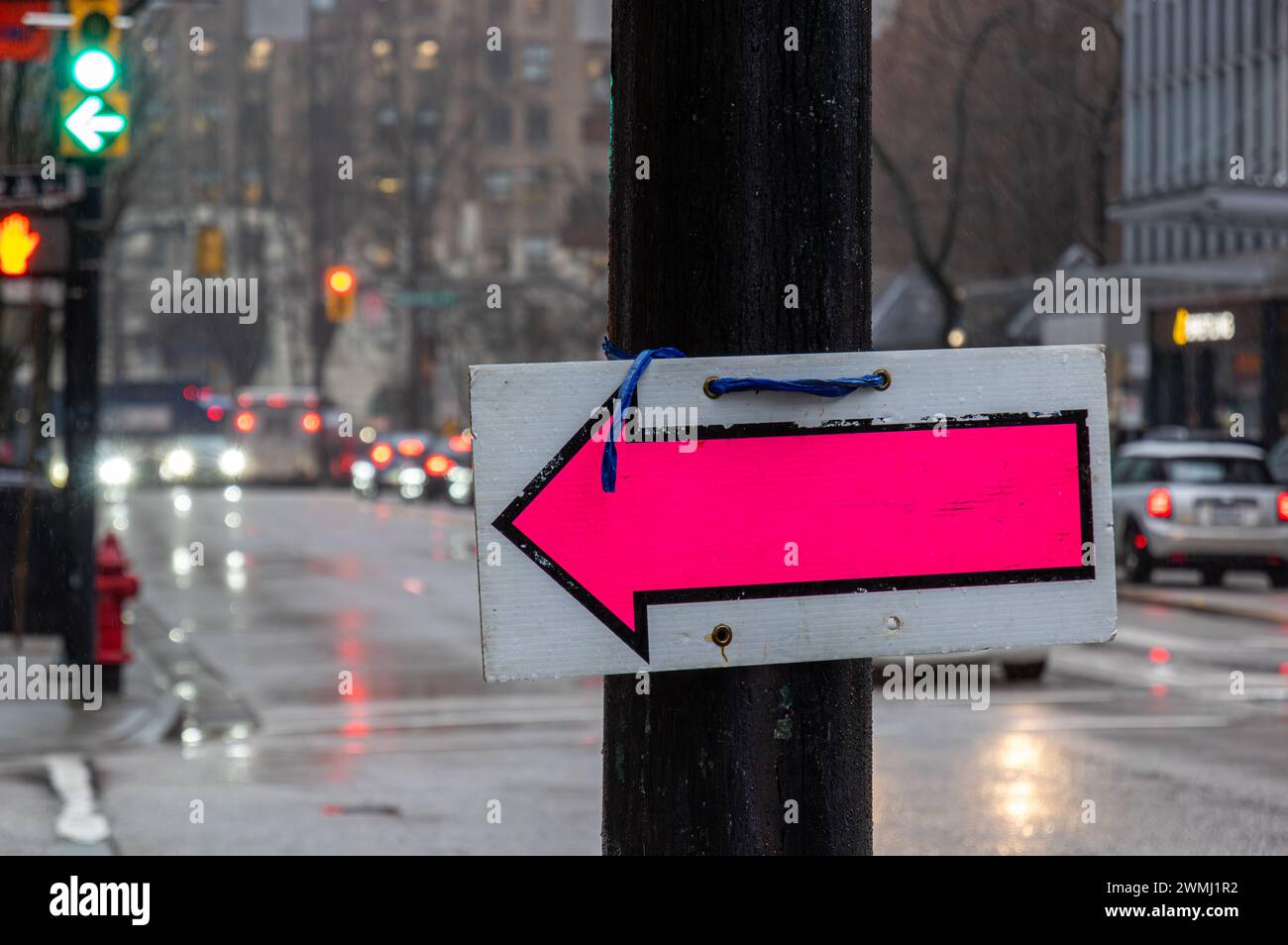 A sign pointing left to a filming location, attached to a traffic light ...