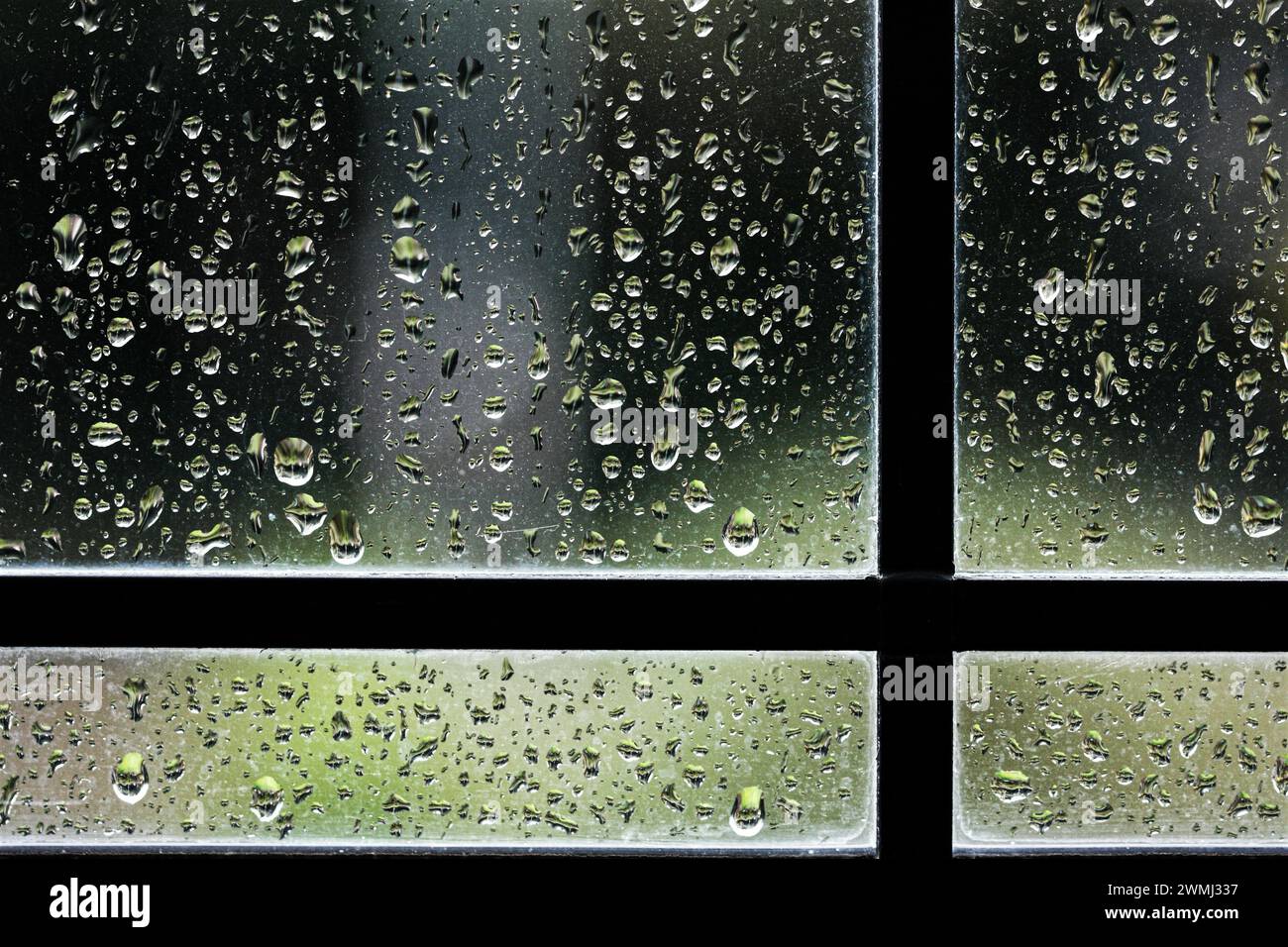 Raindrops on leaded glass window pane close up. The photo of this wet weather background was ...