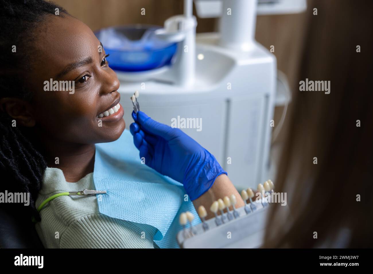 Dentist holding dental teeth shade guide chart for female patient ...