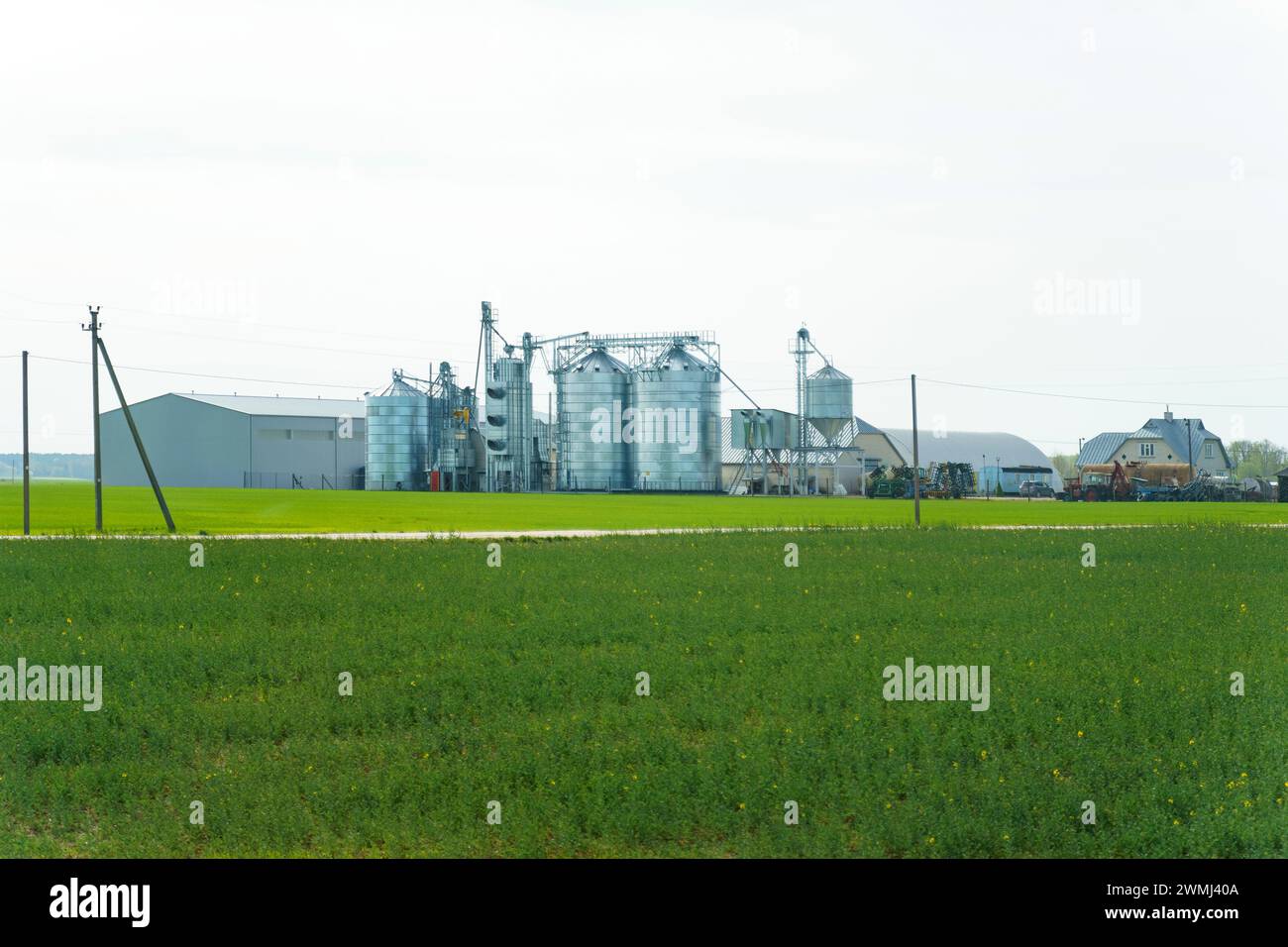 A modern agricultural setup featuring tall metal grain silos connected ...