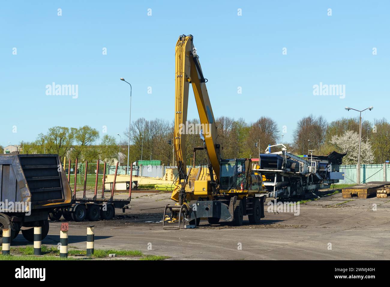 A large yellow truck crane moves upward while participating in loading ...
