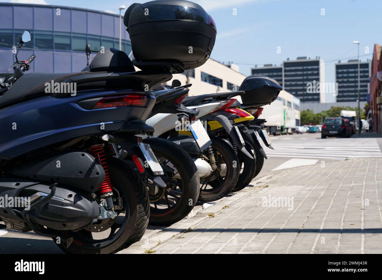 A row of motorcycles lined up neatly next to each other in a parking ...