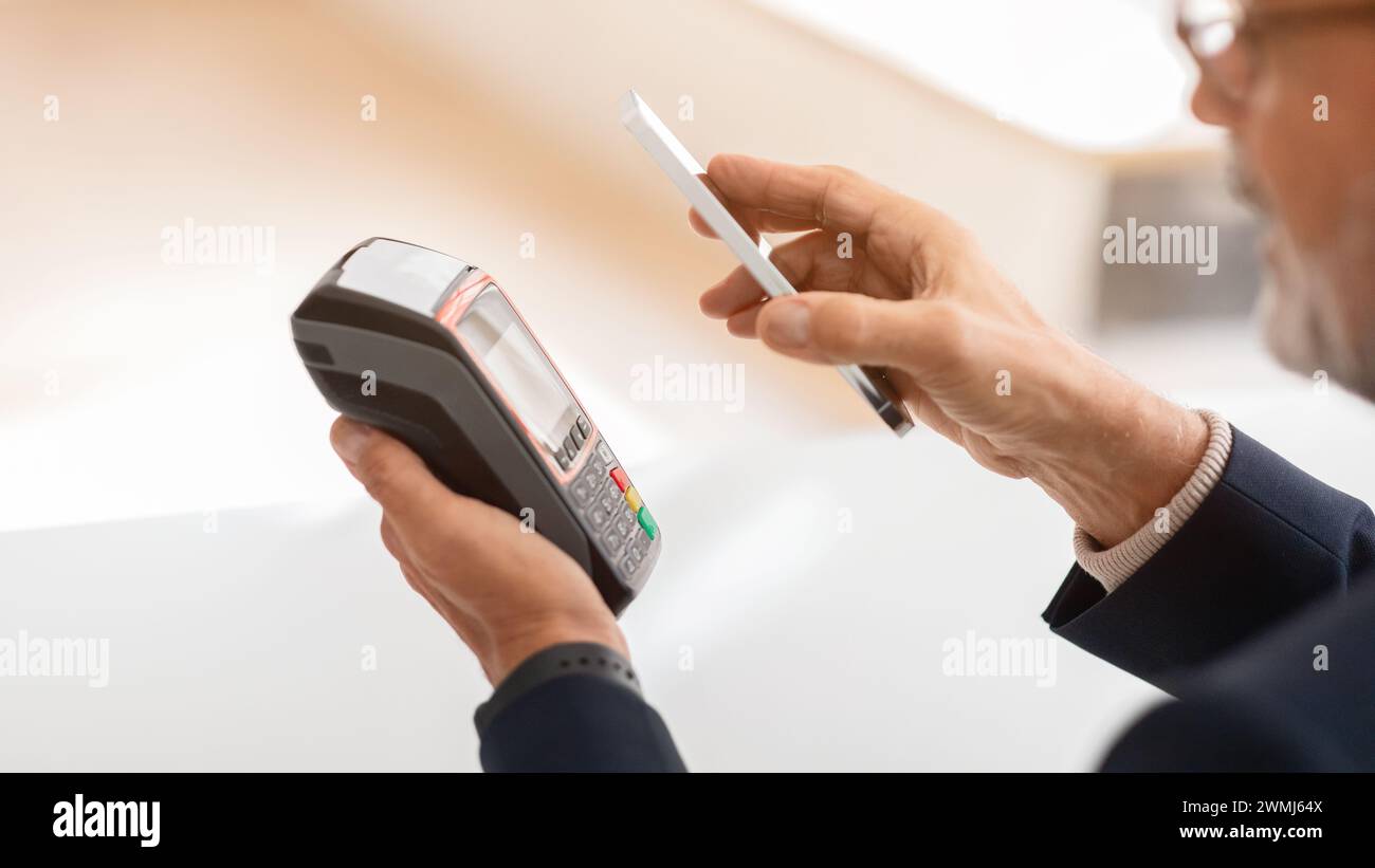 A businessman in a suit processes a card payment using a modern card ...