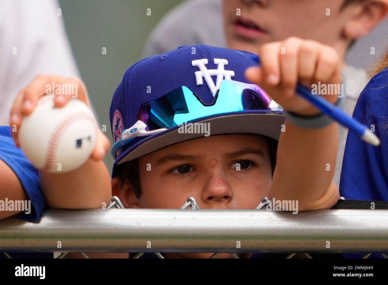 A fan wearing Los Angeles Dodgers gear waits for players to sign ...