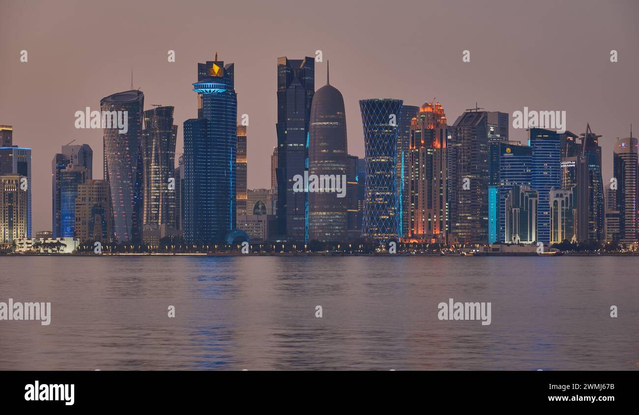 Doha, Qatar skyline from the corniche promenade at night with dhows and ...