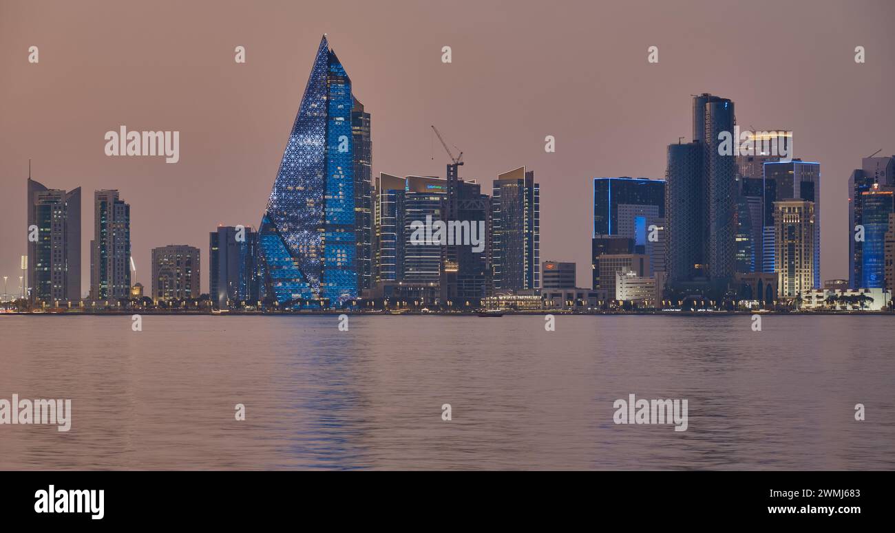 Doha, Qatar skyline from the corniche promenade at night with dhows and ...