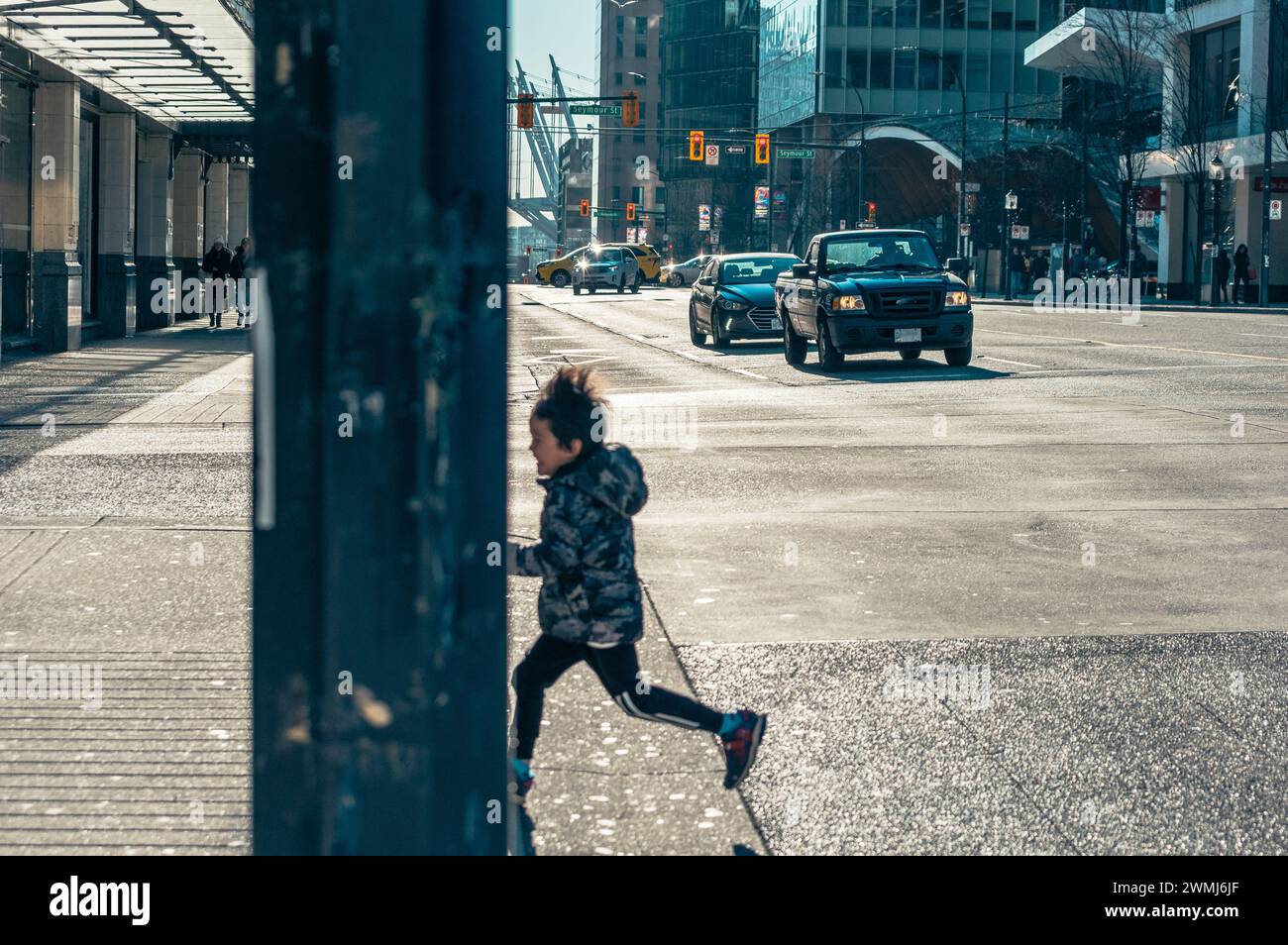 A child jumping on the sidewalk after running across Georgia Street in ...
