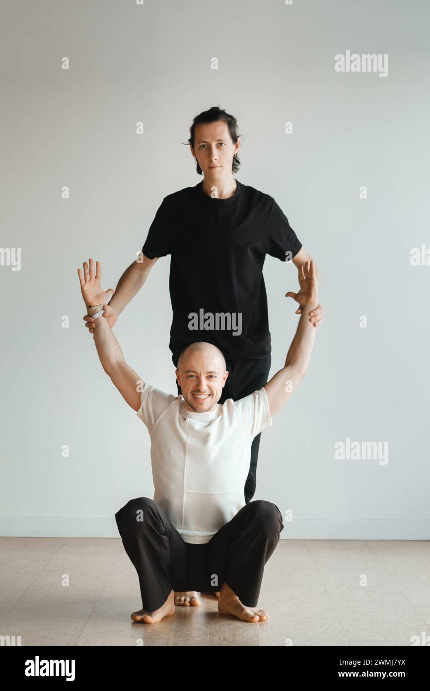 two young athletes practice yoga in the gym. Joint training, indoors ...