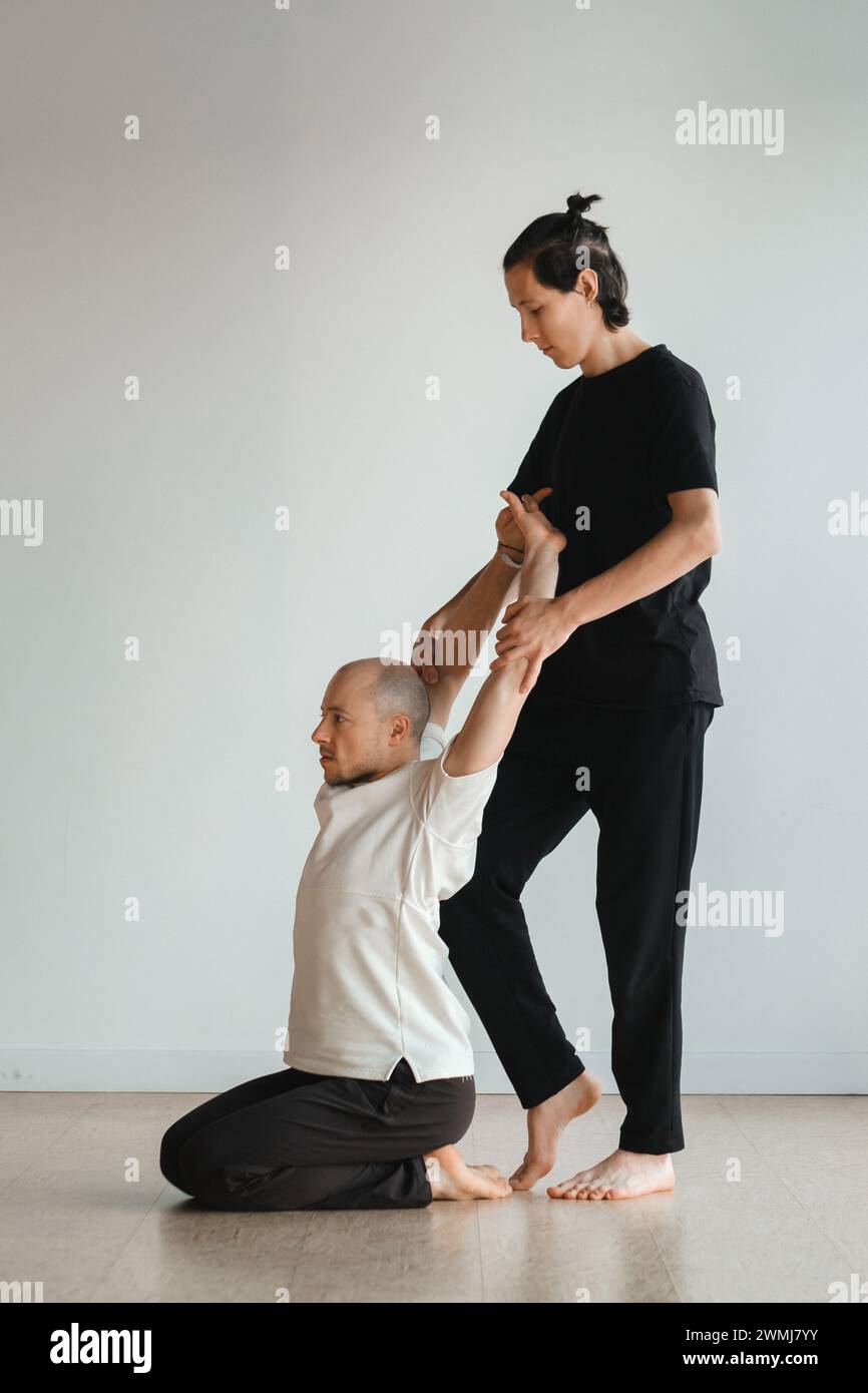 two young athletes practice yoga in the gym. Joint training, indoors ...