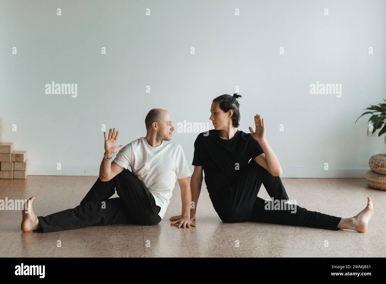 two young athletes practice yoga in the gym. Joint training, indoors ...
