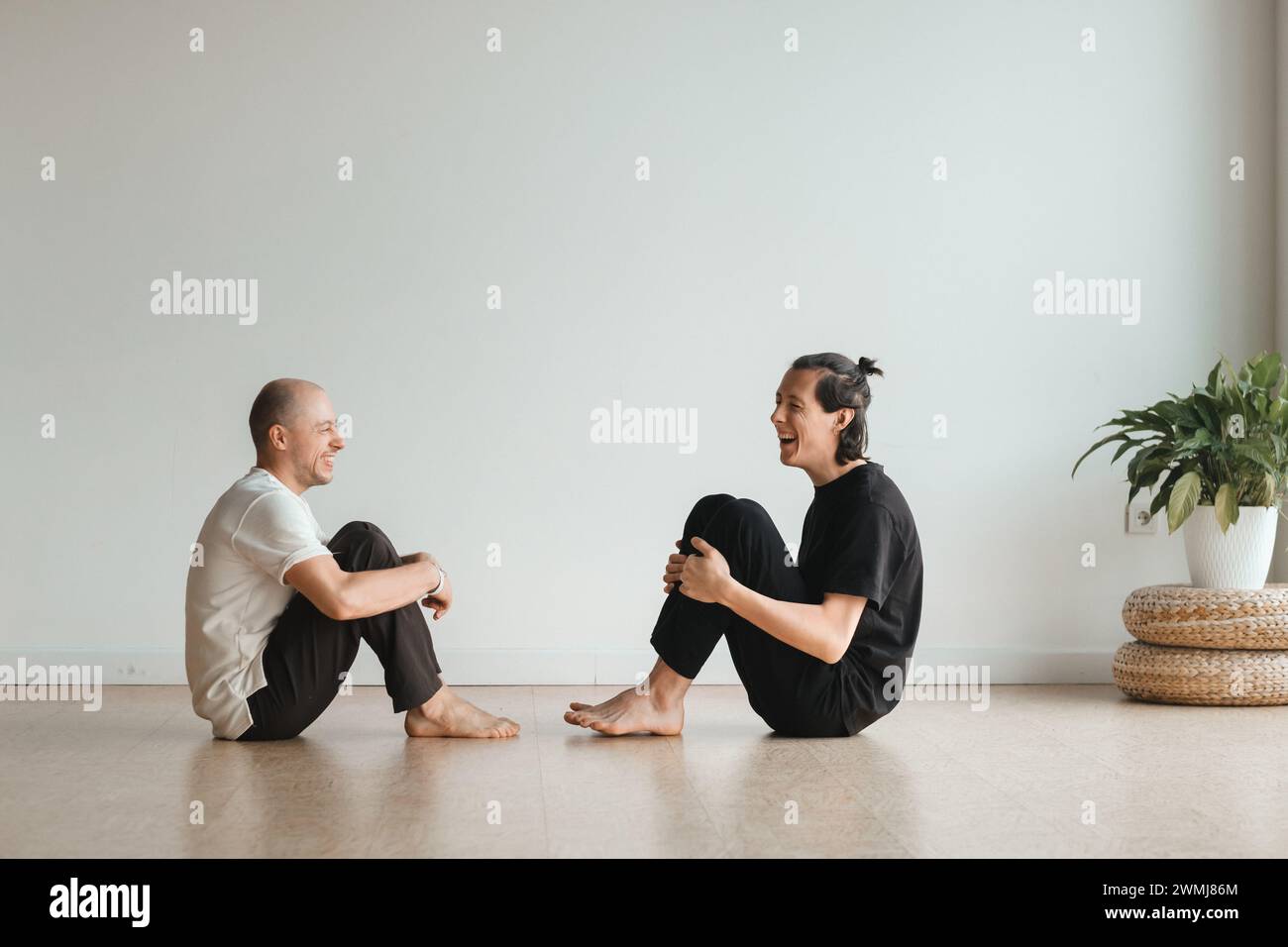two young athletes practice yoga in the gym. Joint training, indoors ...
