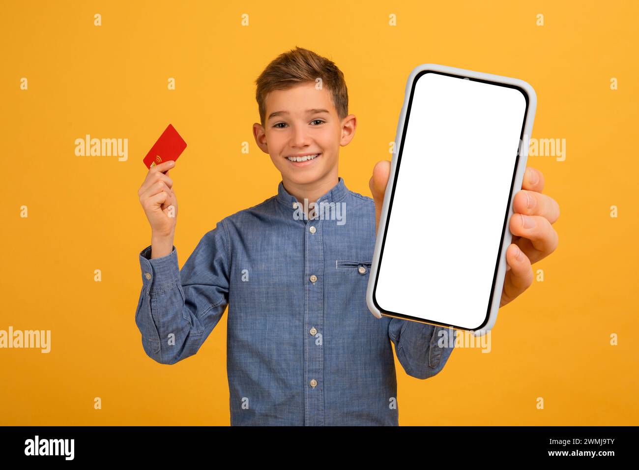 Smiling teen boy holding credit card and showing smartphone with blank screen Stock Photo - Alamy