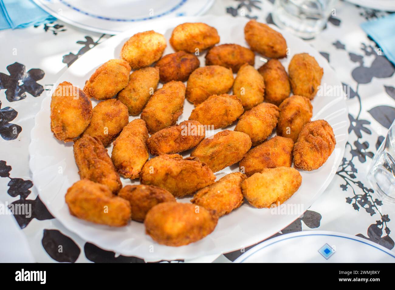 A platter of golden-brown Spanish croquetas from stew, ready to be ...