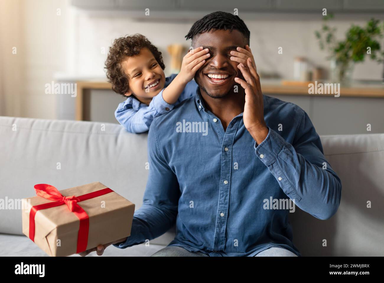 Black son surprises dad with gift, covering his eyes from back Stock ...
