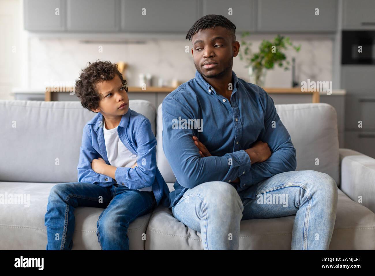 Black father and son with arms crossed, looking serious Stock Photo - Alamy