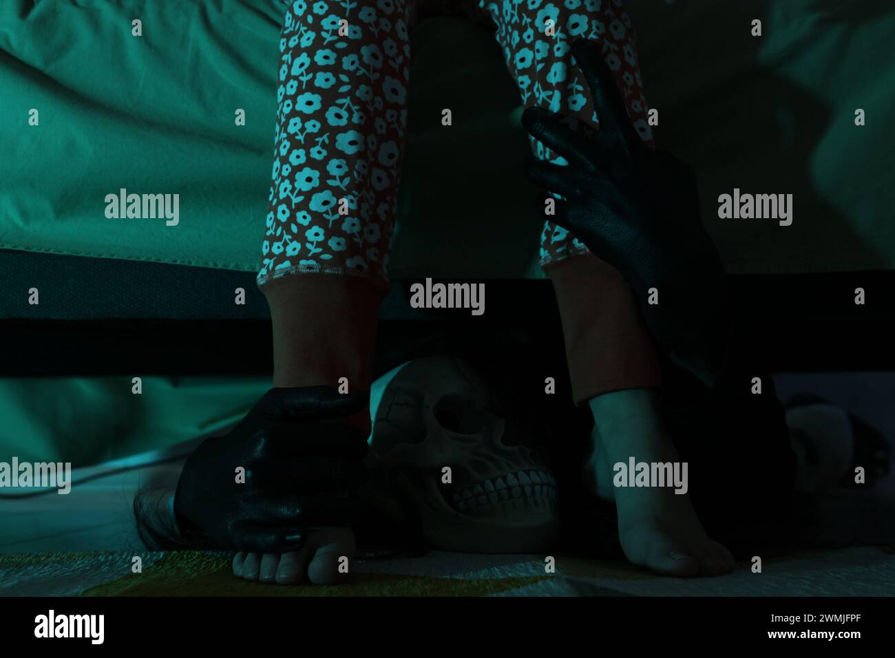 Scary monster under bed grabbing little girl by legs in darkness ...