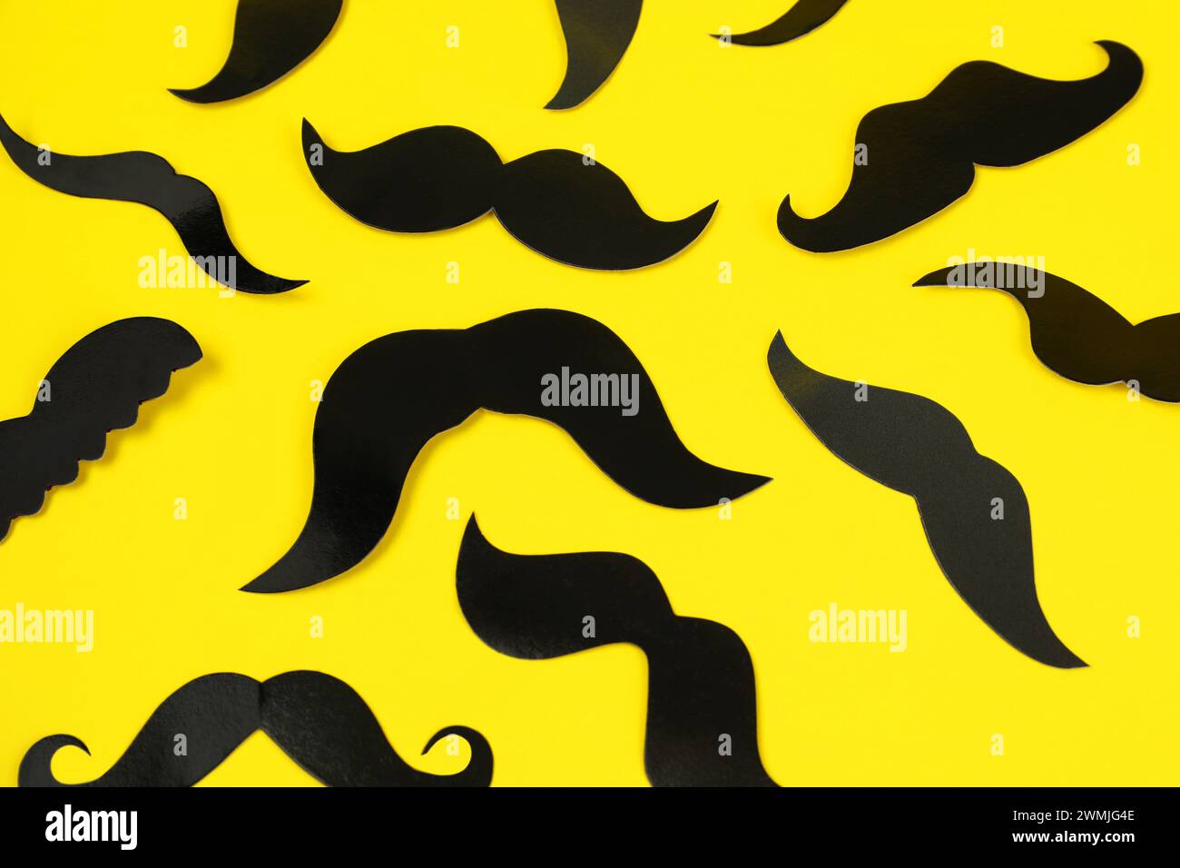 Many fake paper mustaches on yellow background Stock Photo - Alamy