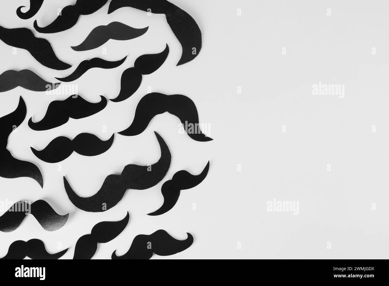 Fake paper mustaches on light background, flat lay. Space for text ...