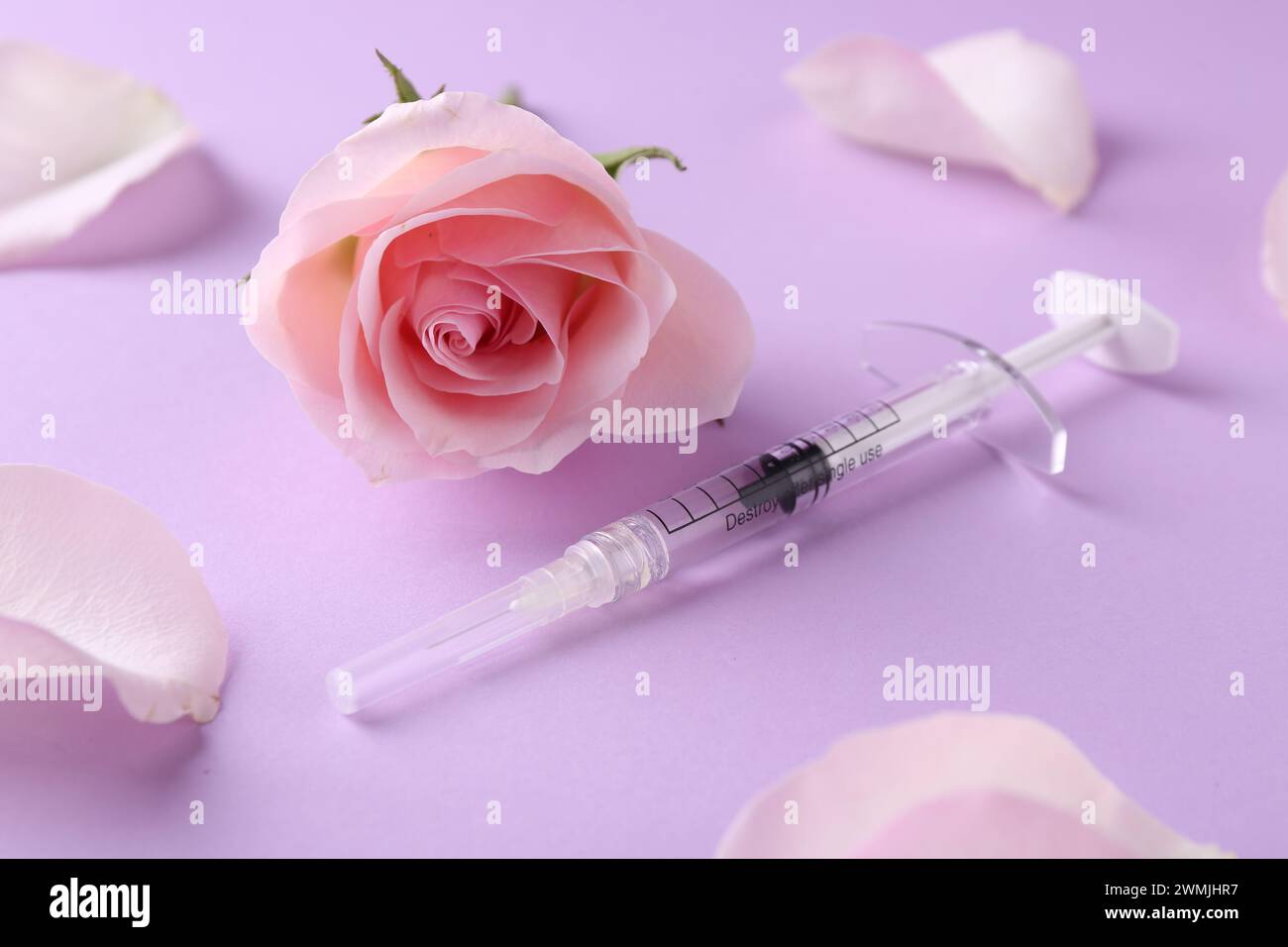 Cosmetology. Medical syringe, rose flower and petals on pink background ...