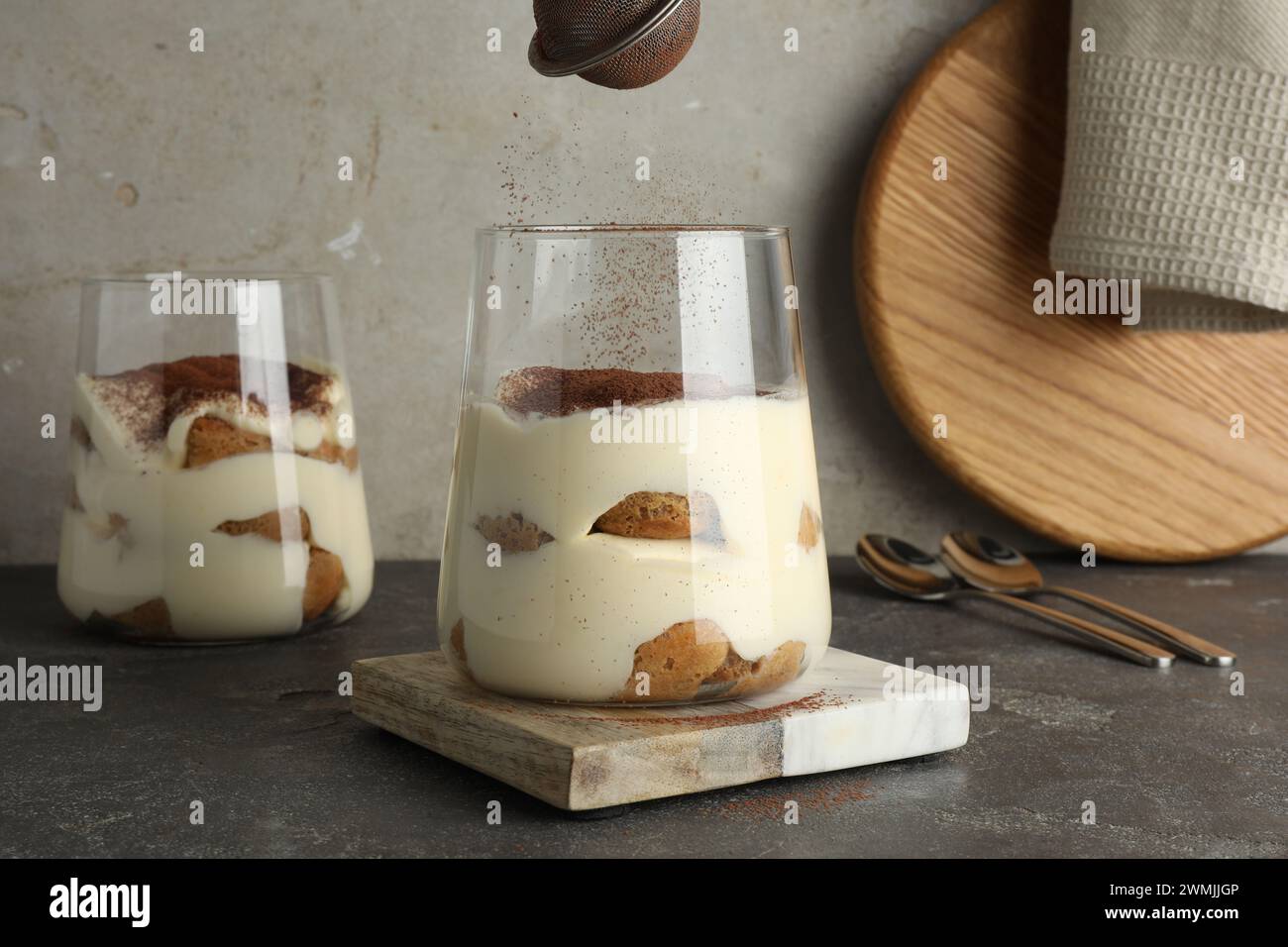 Delicious tiramisu in glasses on grey table Stock Photo - Alamy