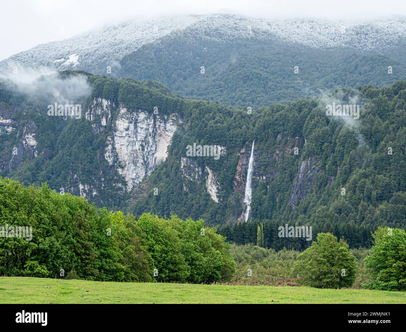 Mountain range with waterfall east of Puerto Aisen, snow on mountains ...