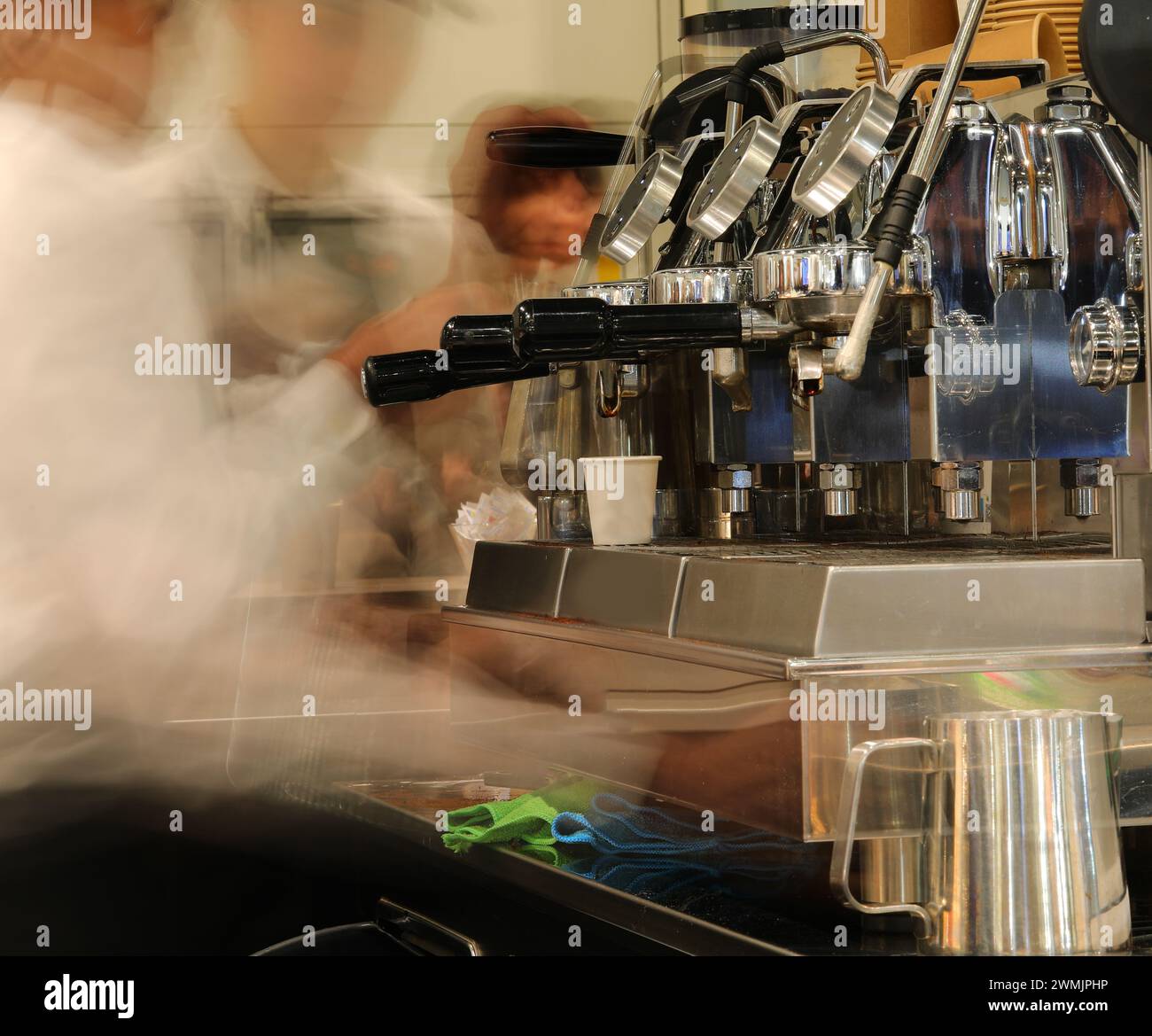 espresso machine in a train station bar with blurred silhouettes of ...