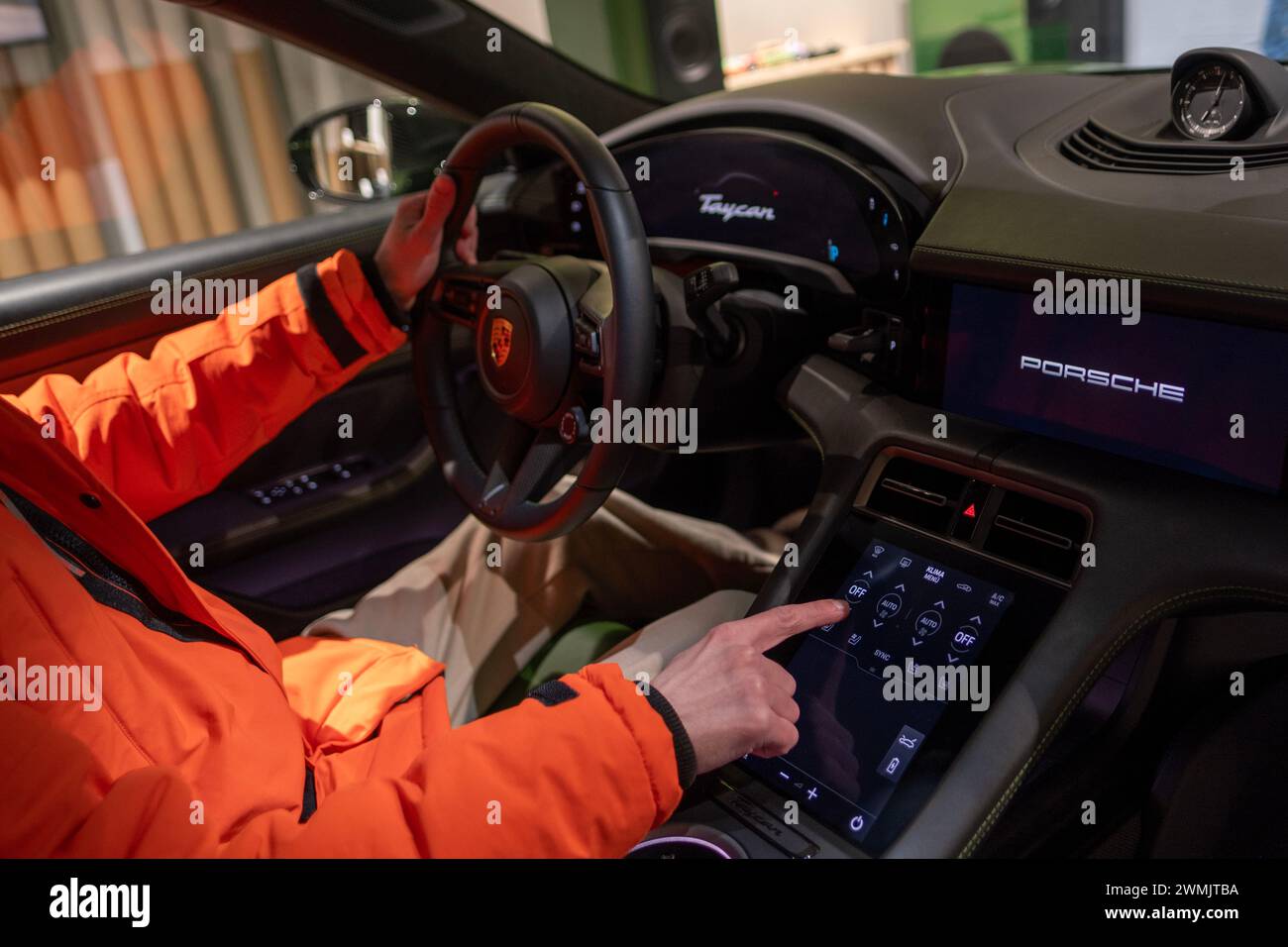 man in car driving Porsche Taycan Turbo S sedan, male hand uses ...