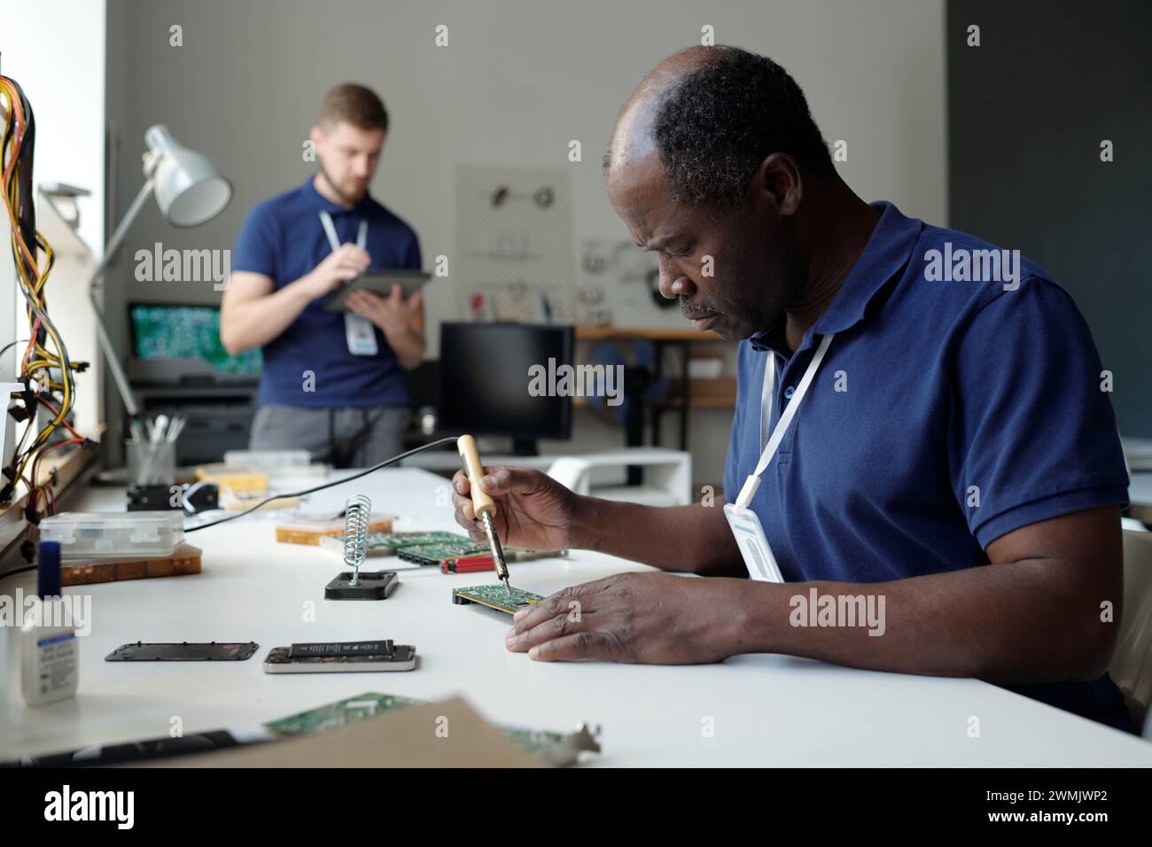 Experienced African American engineer of repair service office sitting ...