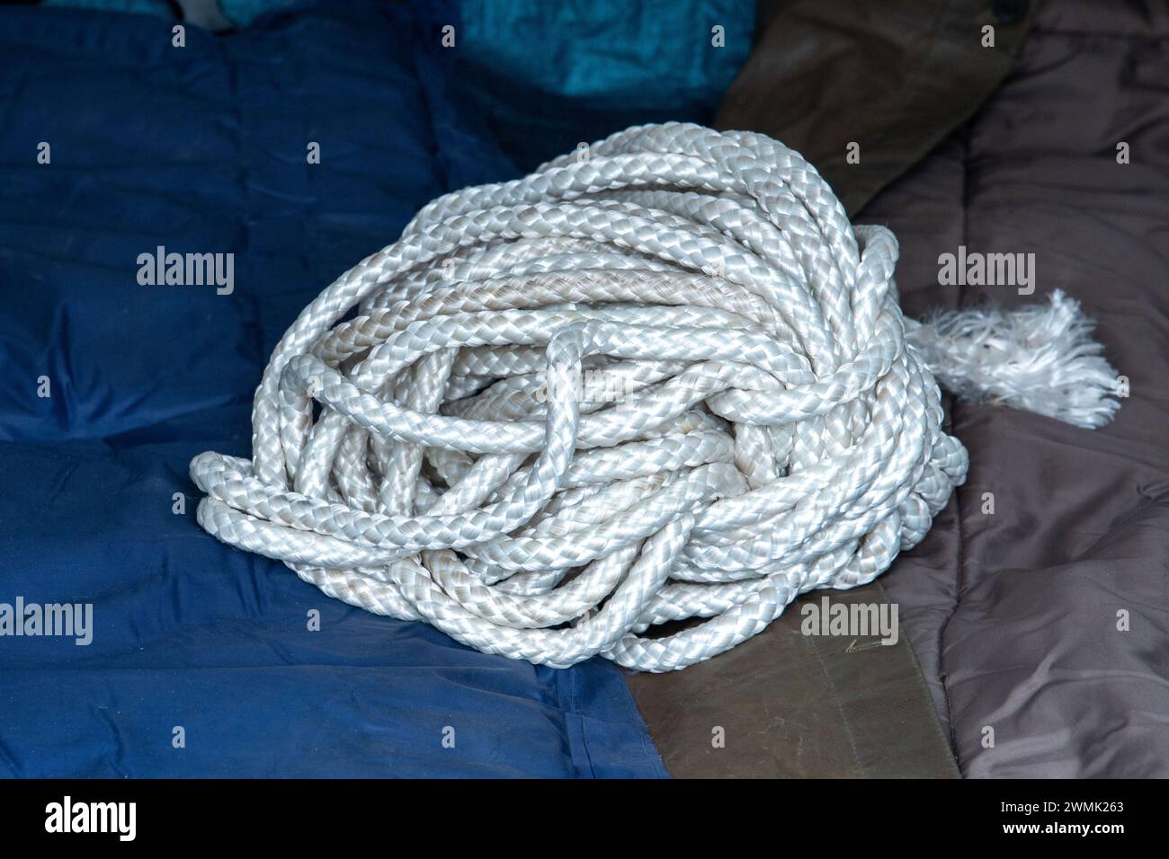 Entwined Enigma. The blue tent and white rope gatrhered, tied up knots ...