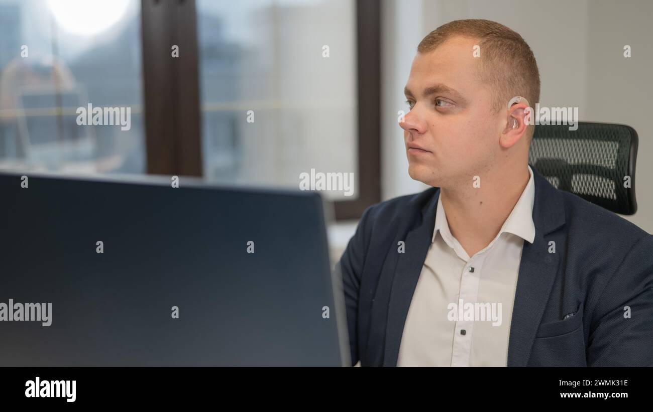 Deaf man working on a computer in the office Stock Photo - Alamy