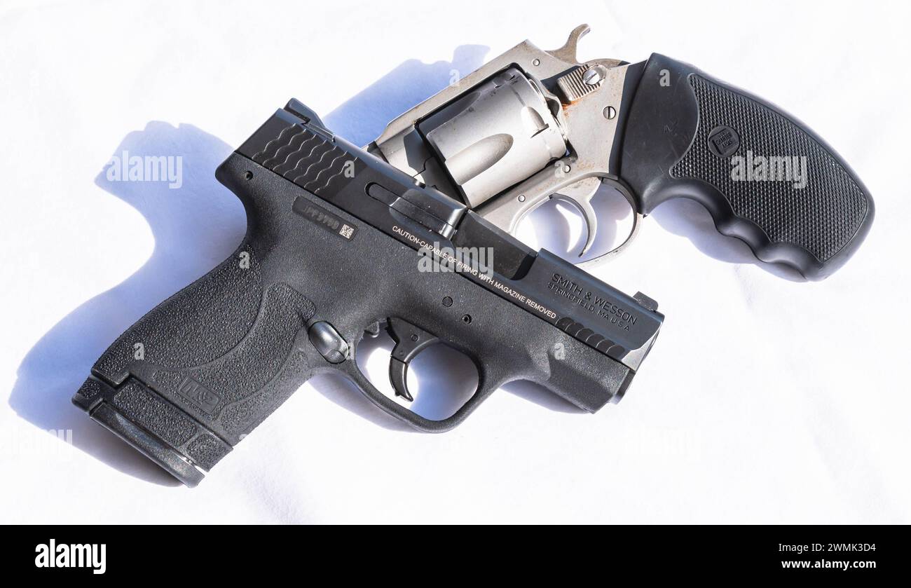 Two handguns, a black pistol and a stainless-steel snub nose revolver ...