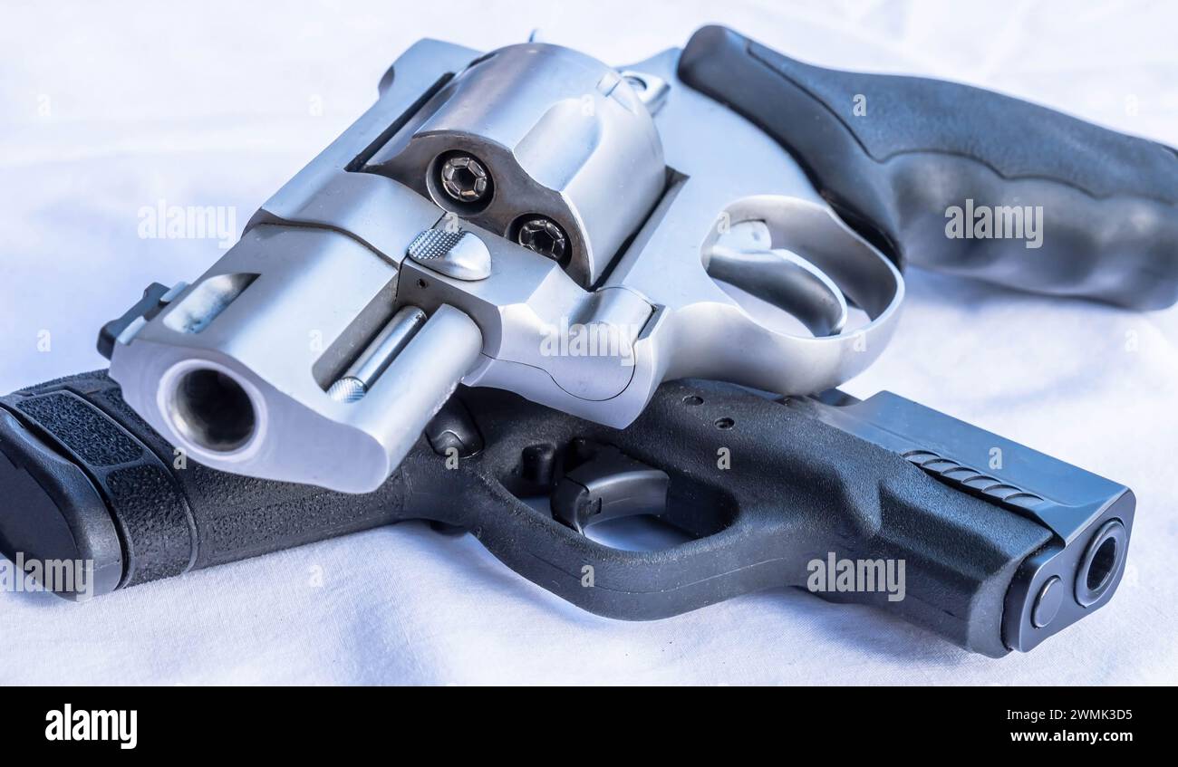 Two handguns, a black pistol and a stainless-steel snub nose revolver ...