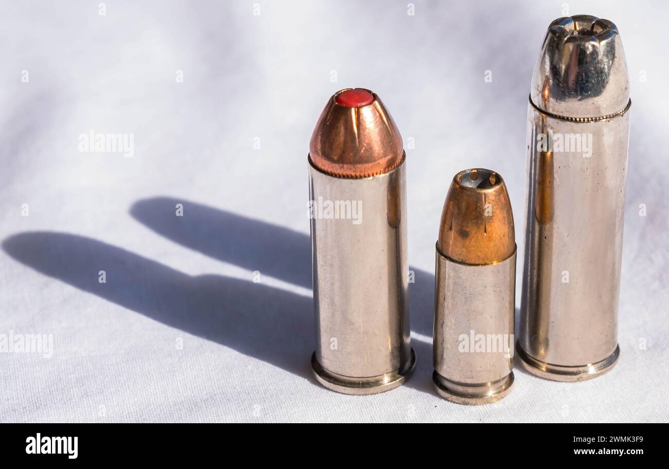 Three hollow point bullets of different calibers on a white background ...
