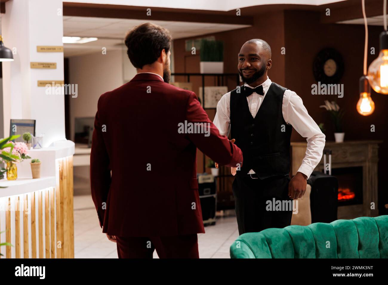 Bellhop shaking hands with businessman, welcoming formal guest at ...