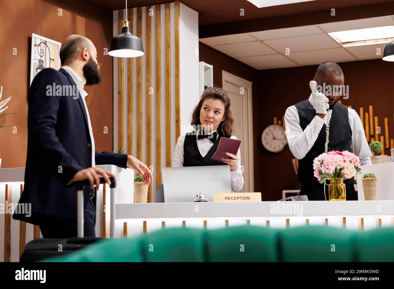 Check in process at reception counter. Front desk staff verifying ...