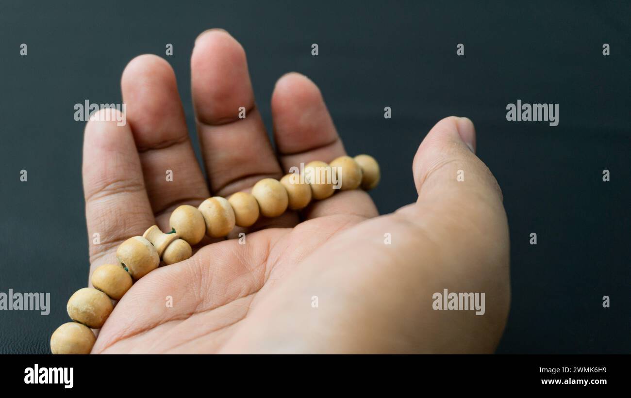 Tasbih made of wood to be used for dhikr dzikir on the hands. On black ...
