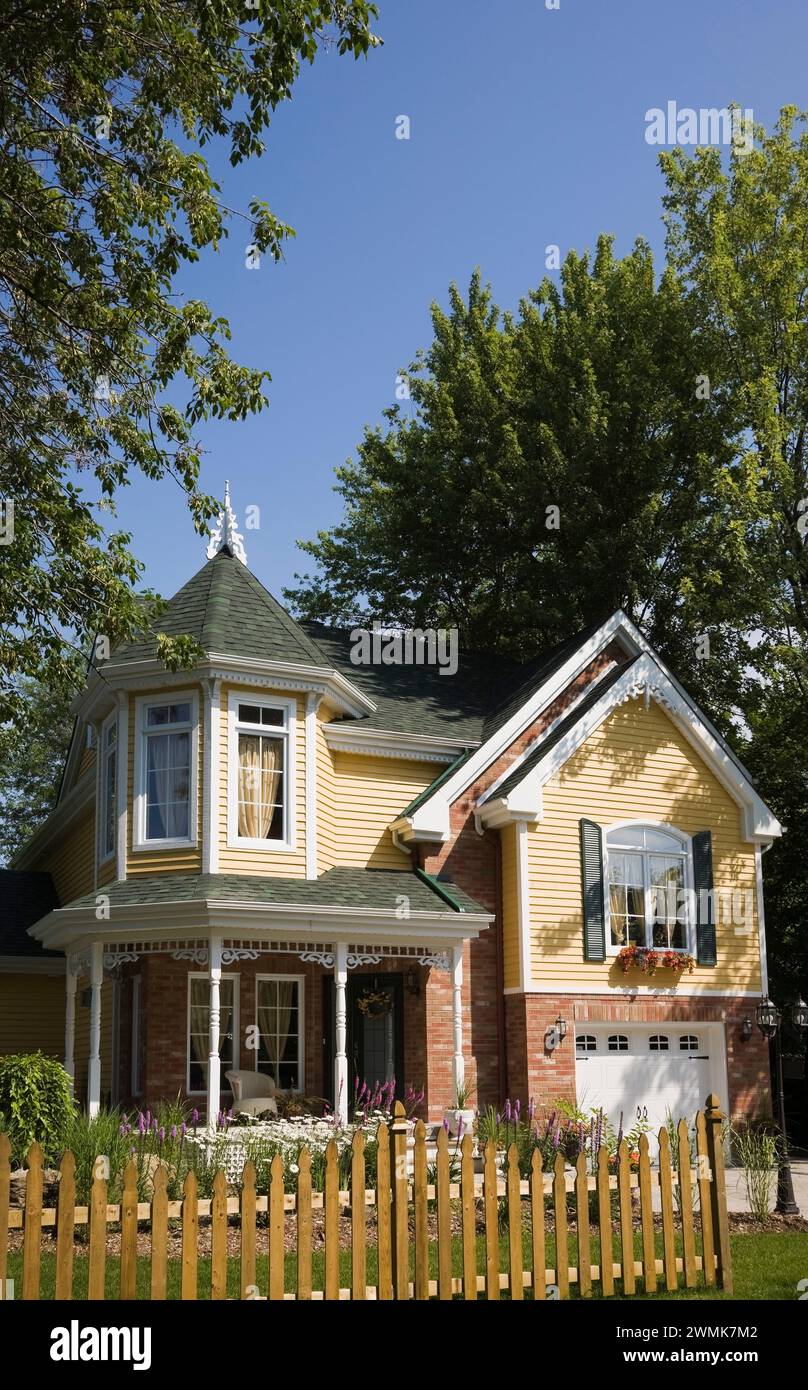 Two storied red brick and yellow clapboard Victorian style home with ...