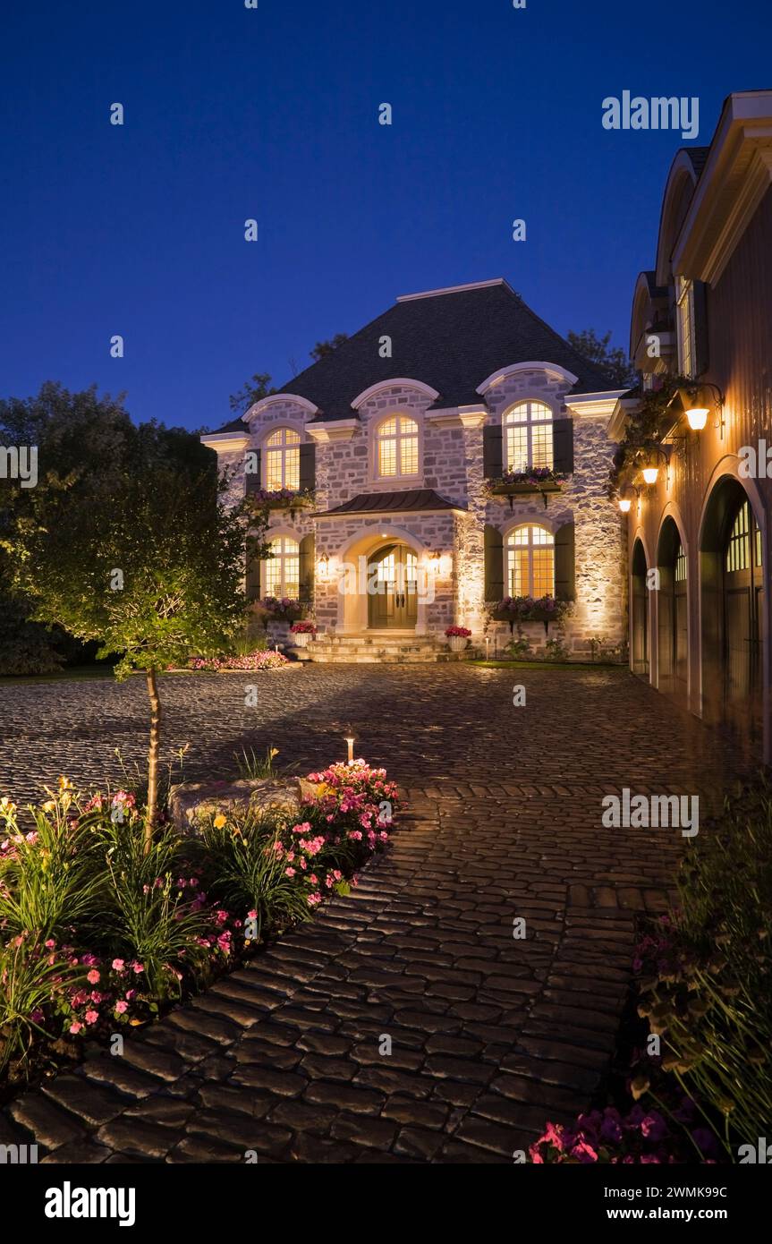 French Manor style natural stone home facade with three car garage and ...