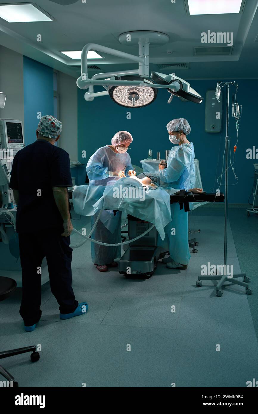 Group of surgeons in operating theater. Medical team performing surgery ...