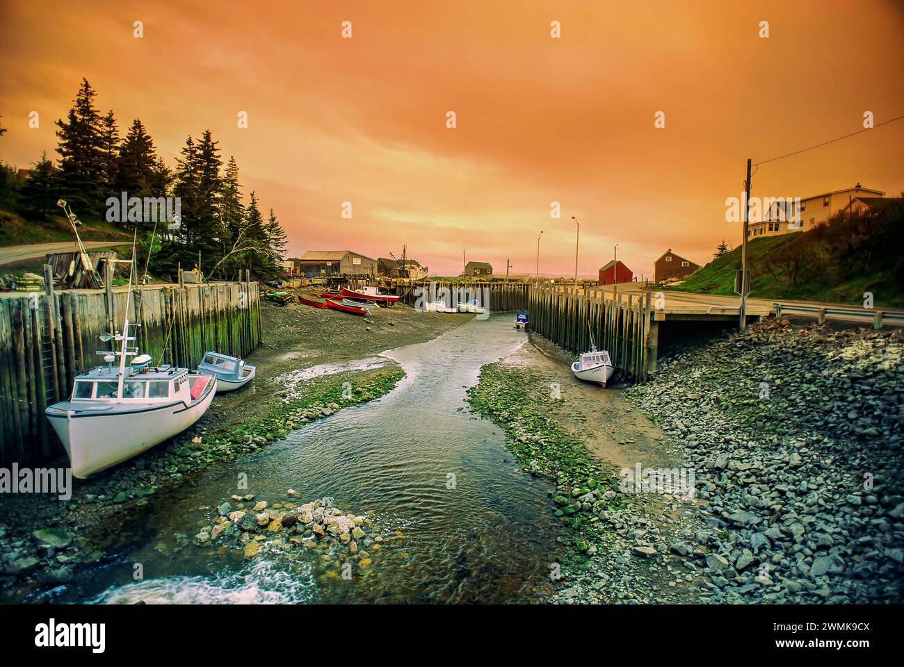 Boats in a canal at low tide, Halls Harbour in the Bay of Fundy; Nova Scotia, Canada Stock Photo ...