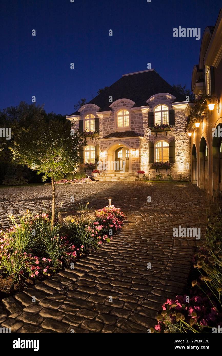 French Manor style natural stone home facade with three car garage and ...