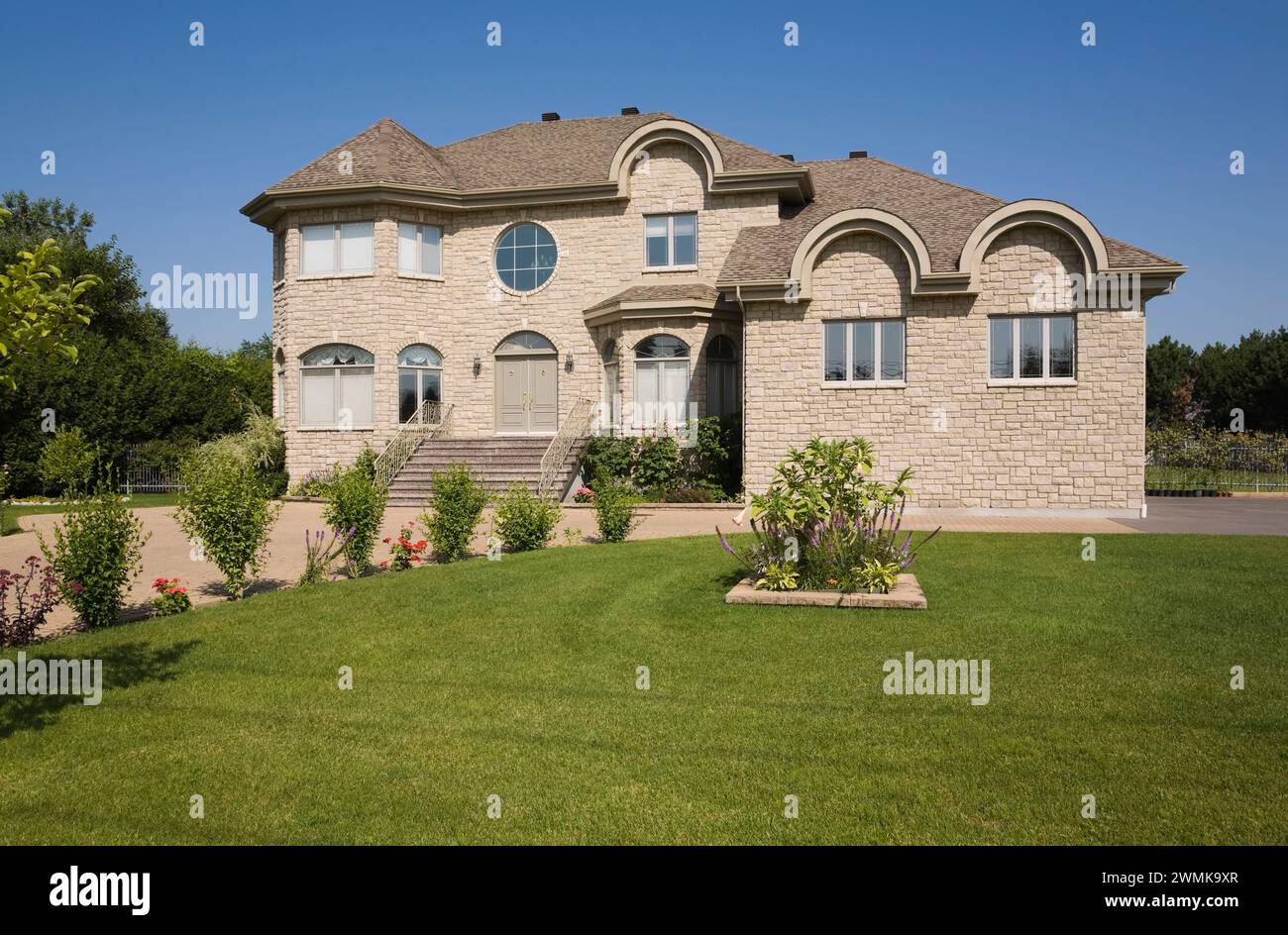 Luxurious two story tan cut stone home with landscaped front yard and ...