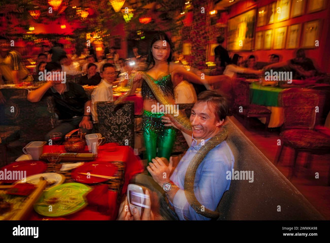 Dancer in green sparkles and fringe performs with a live snake at the ...