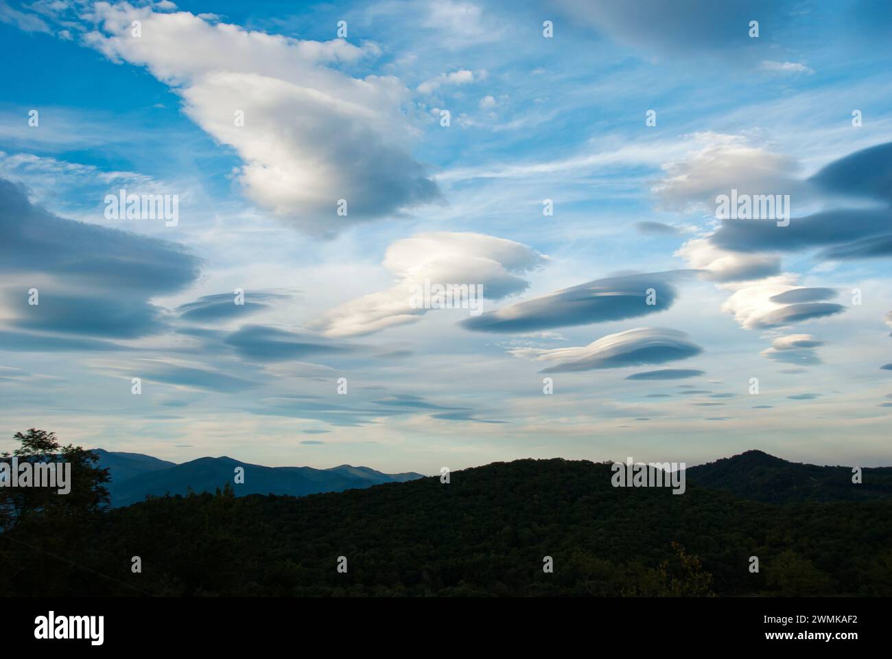 Lenticular clouds form over mountains Stock Photo - Alamy