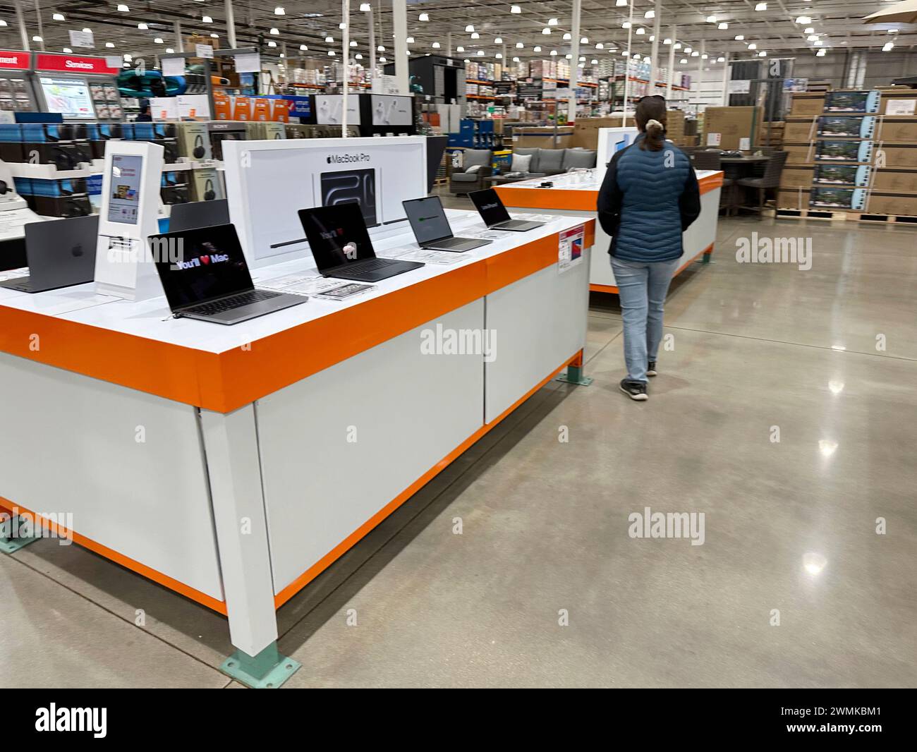 A shopper passes by a display of laptop computers in a Costco warehouse ...