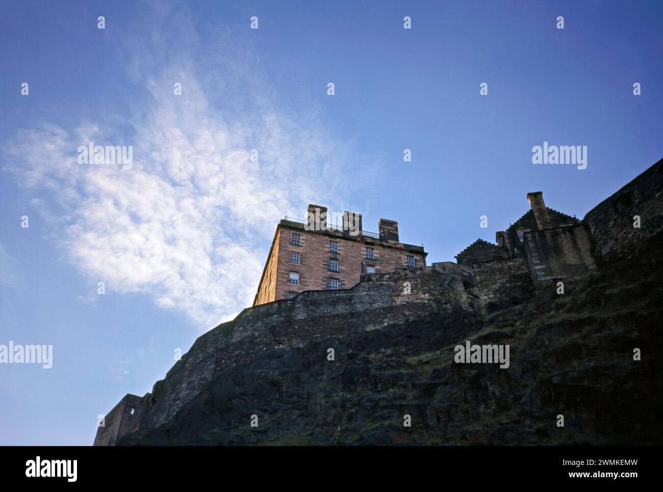 Buildings in a walled city along the edge of a high cliff, against a ...